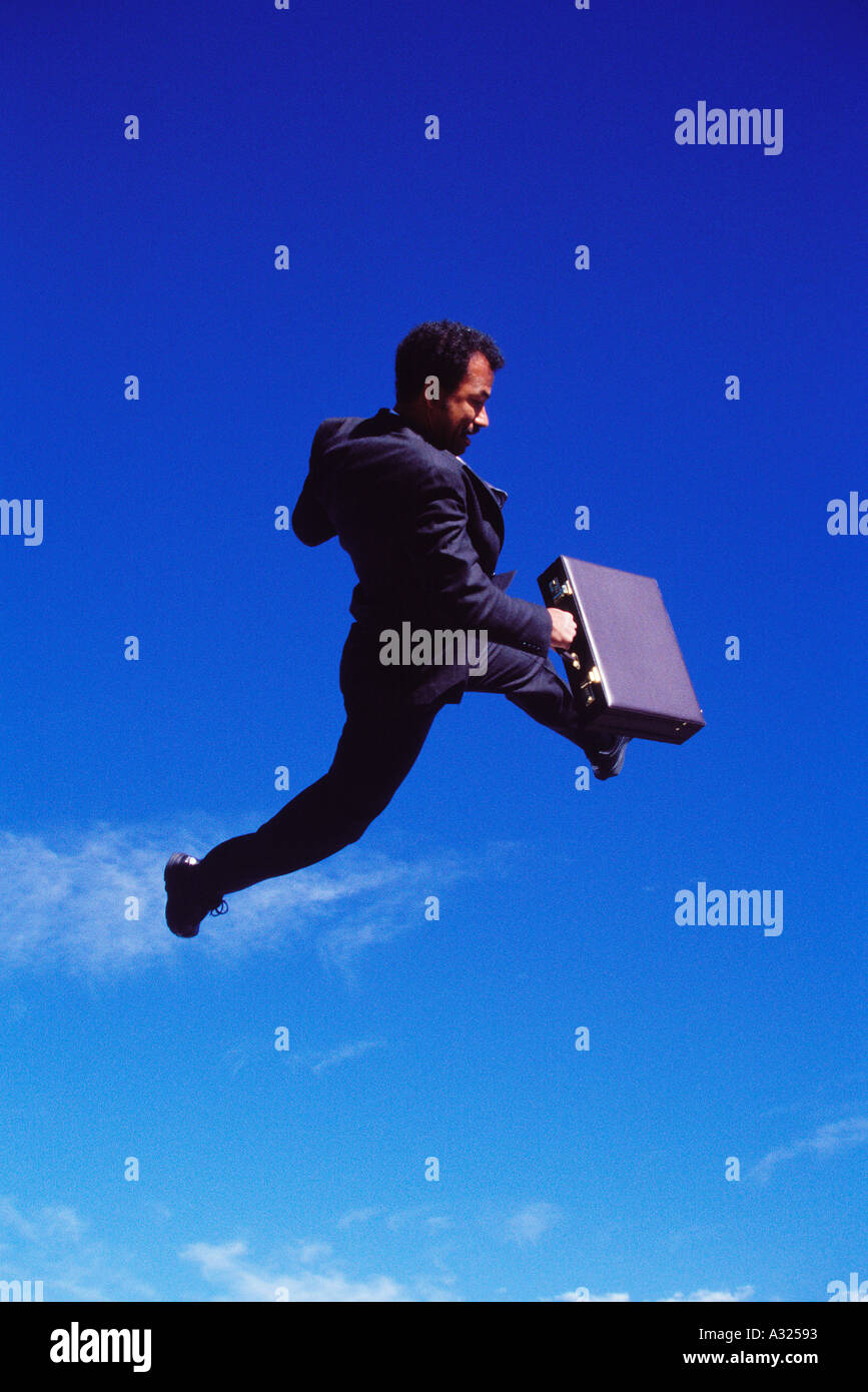 A businessman carrying a briefcase appears to be flying through the air ...
