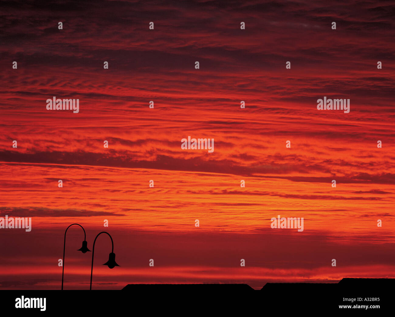 Two street lights turning off with a ruddy sky Stock Photo - Alamy