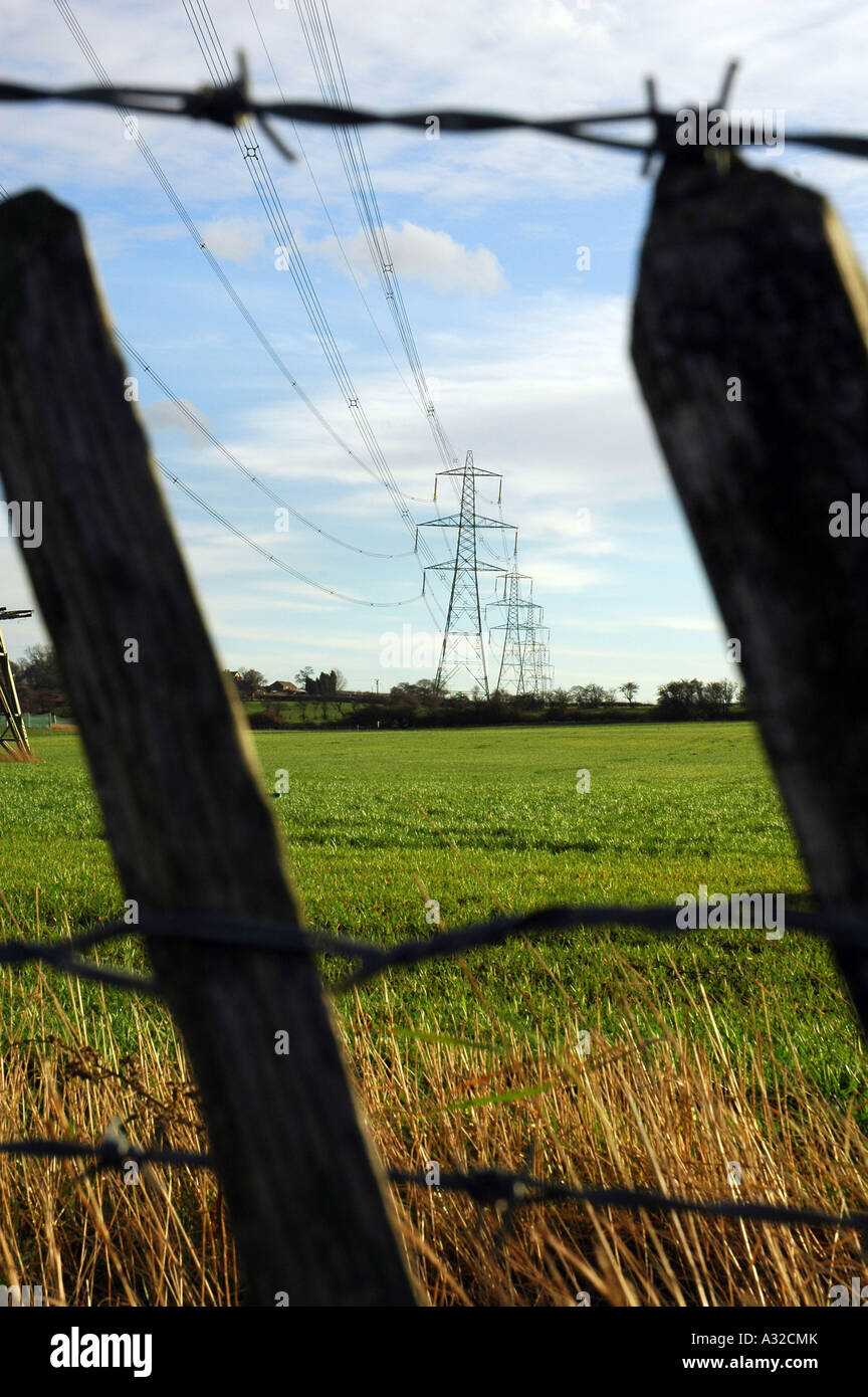 Electricity pylon in a farmer's field viewed through a rustic barbed ...