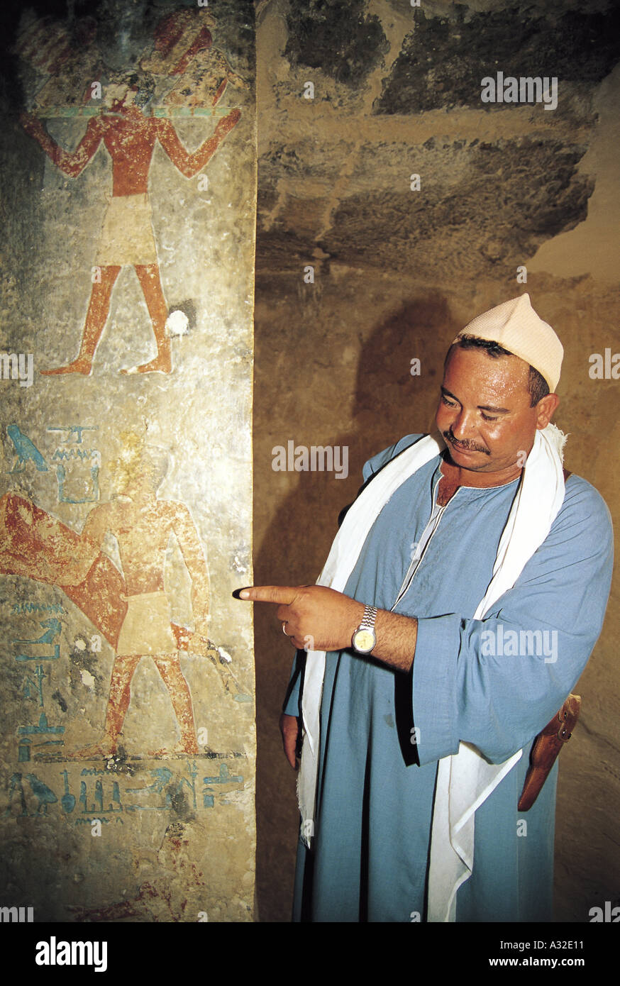 Guide pointing to a mural in the cave tombs of Mir, Egypt, 12th ...