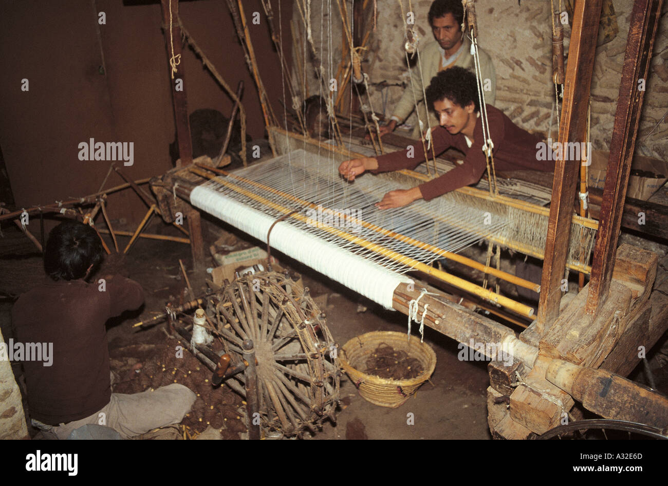 Three Berber men spinning and weaving traditional carpets, Fez, Morocco ...