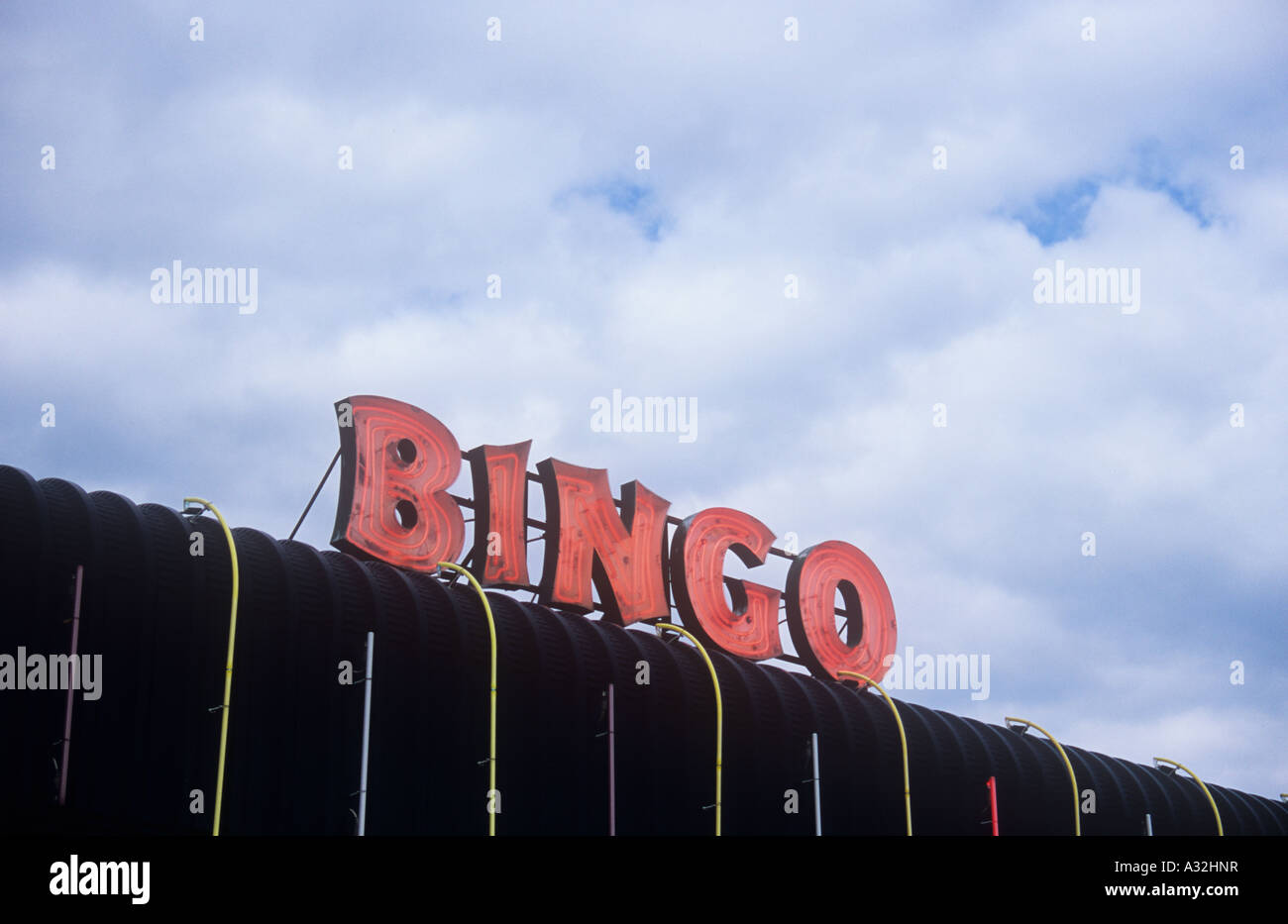 Red neon sign stating Bingo on black plastic roof with coloured strip ...