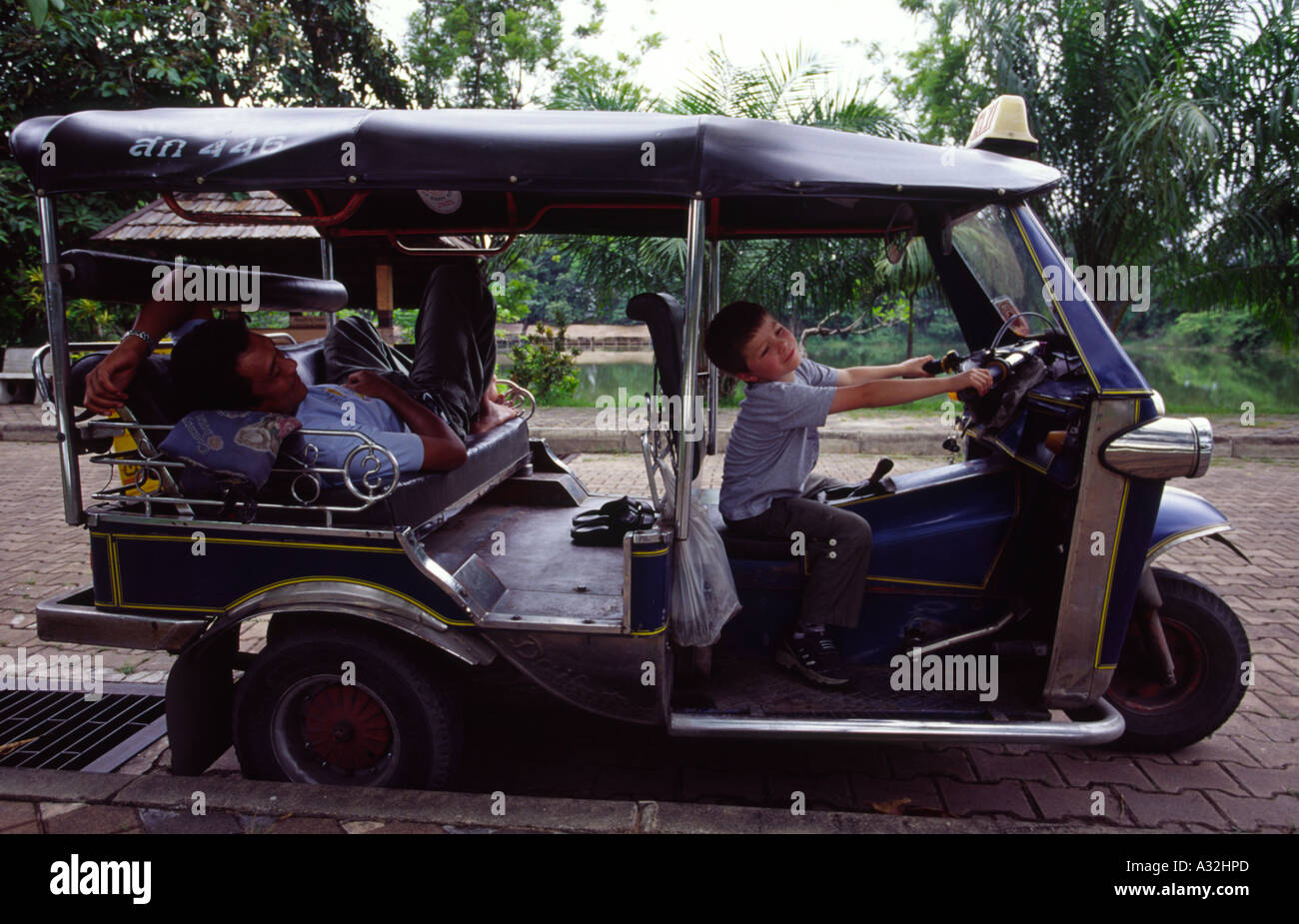 Small white boy on holiday in Thailand pretends to drive a tuk tuk ...