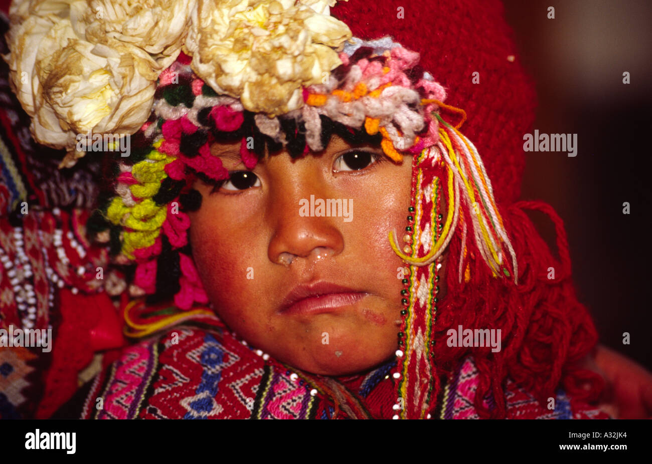 Peruvian boy in traditional dress with hat, bright colours and flowers ...