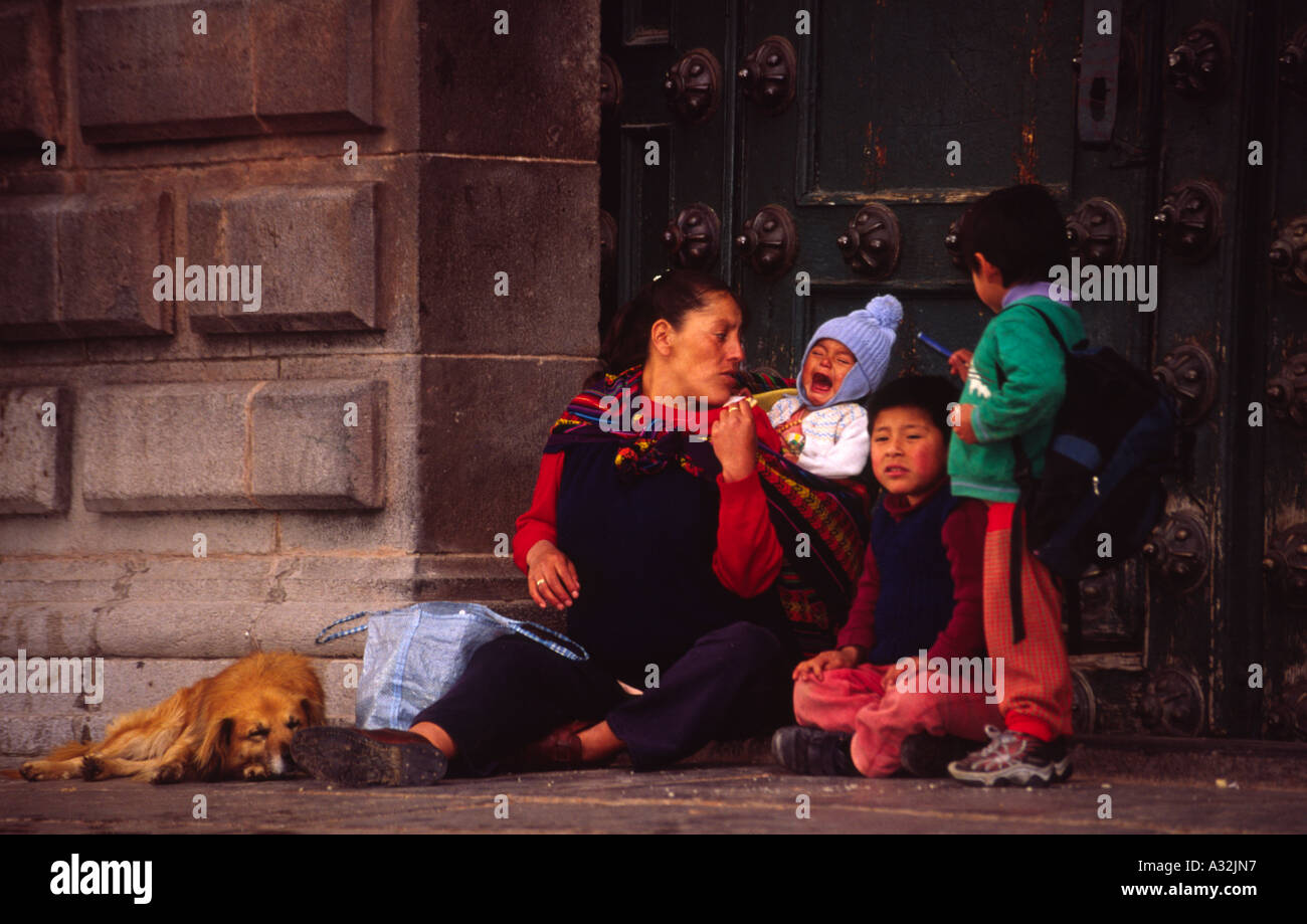 Peruvian family sit on steps of cathedral in Cusco main Square, Peru ...