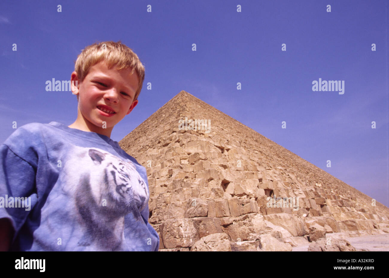 Horizontal wideangle portrait of European boy tourist by the Pyramids ...