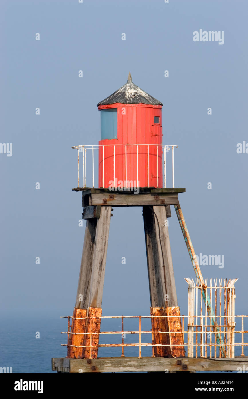 Red wooden lighthouse built on wooden legs, with white safety fence on ...