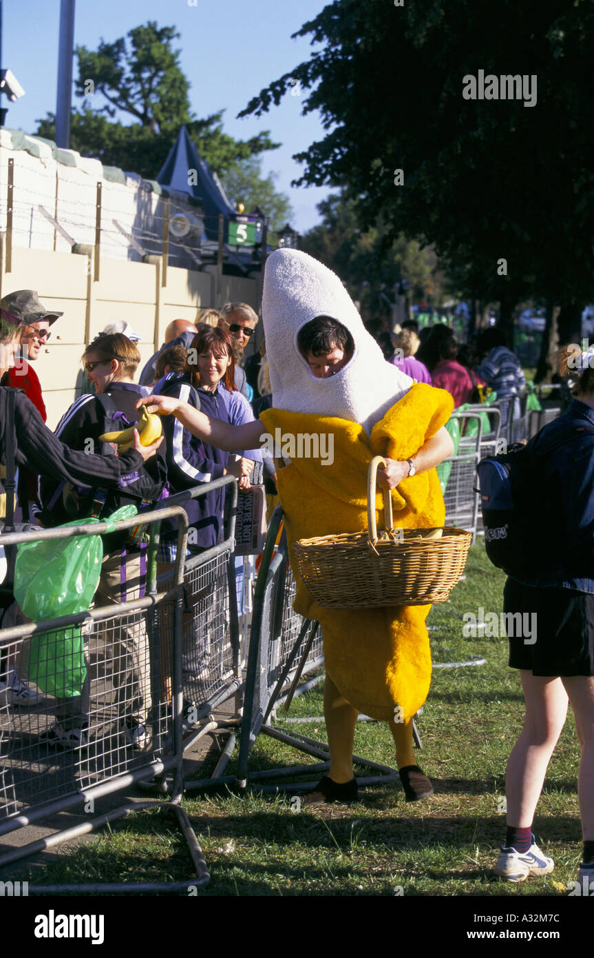 man dressed in banana suit handing bunch of bananas taken from basket ...