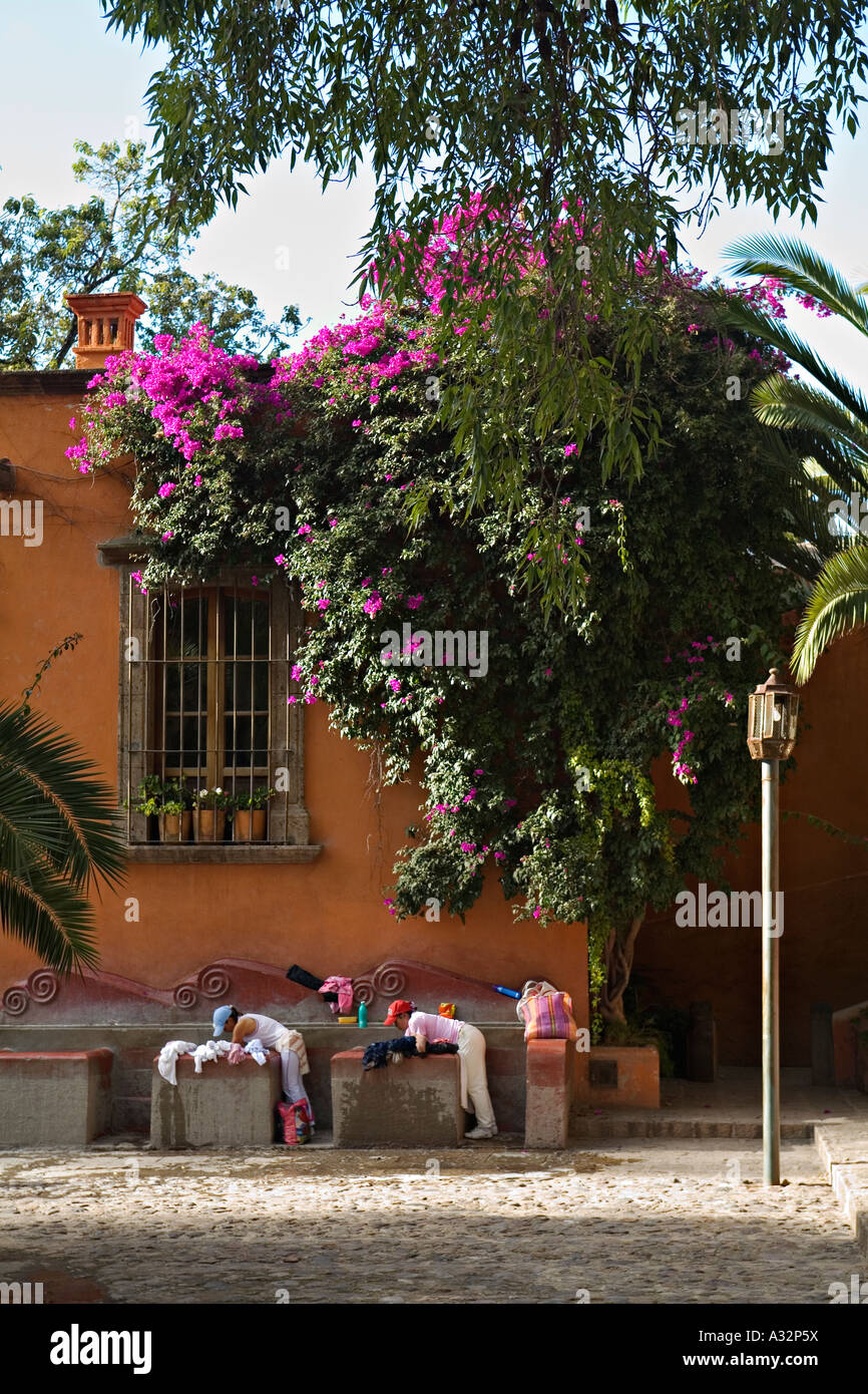 MEXICO San Miguel de Allende Two women wash clothes by hands in outdoor ...