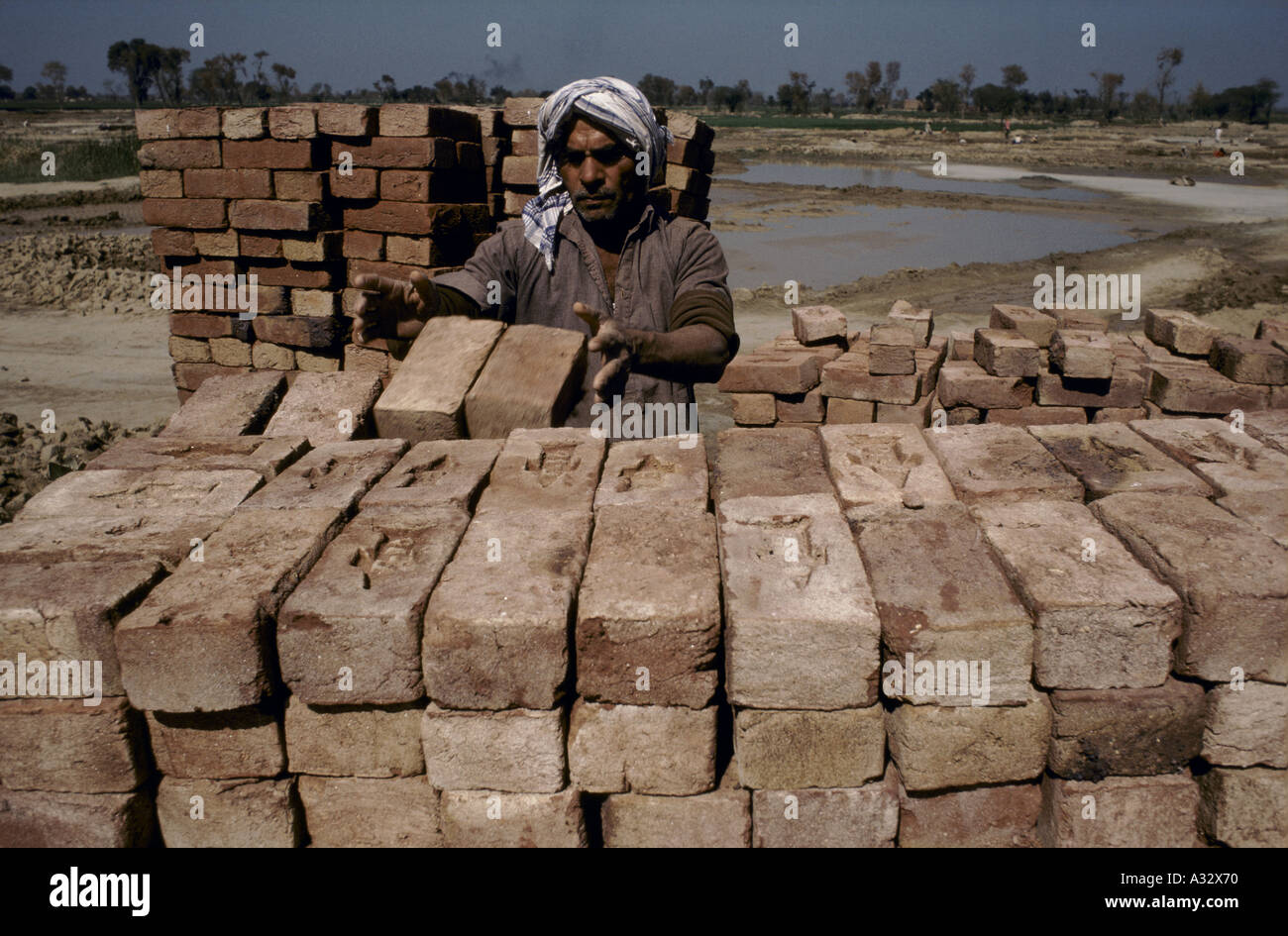 Bonded labor, a man stacking bricks in a brick kiln. Pakistan Stock ...