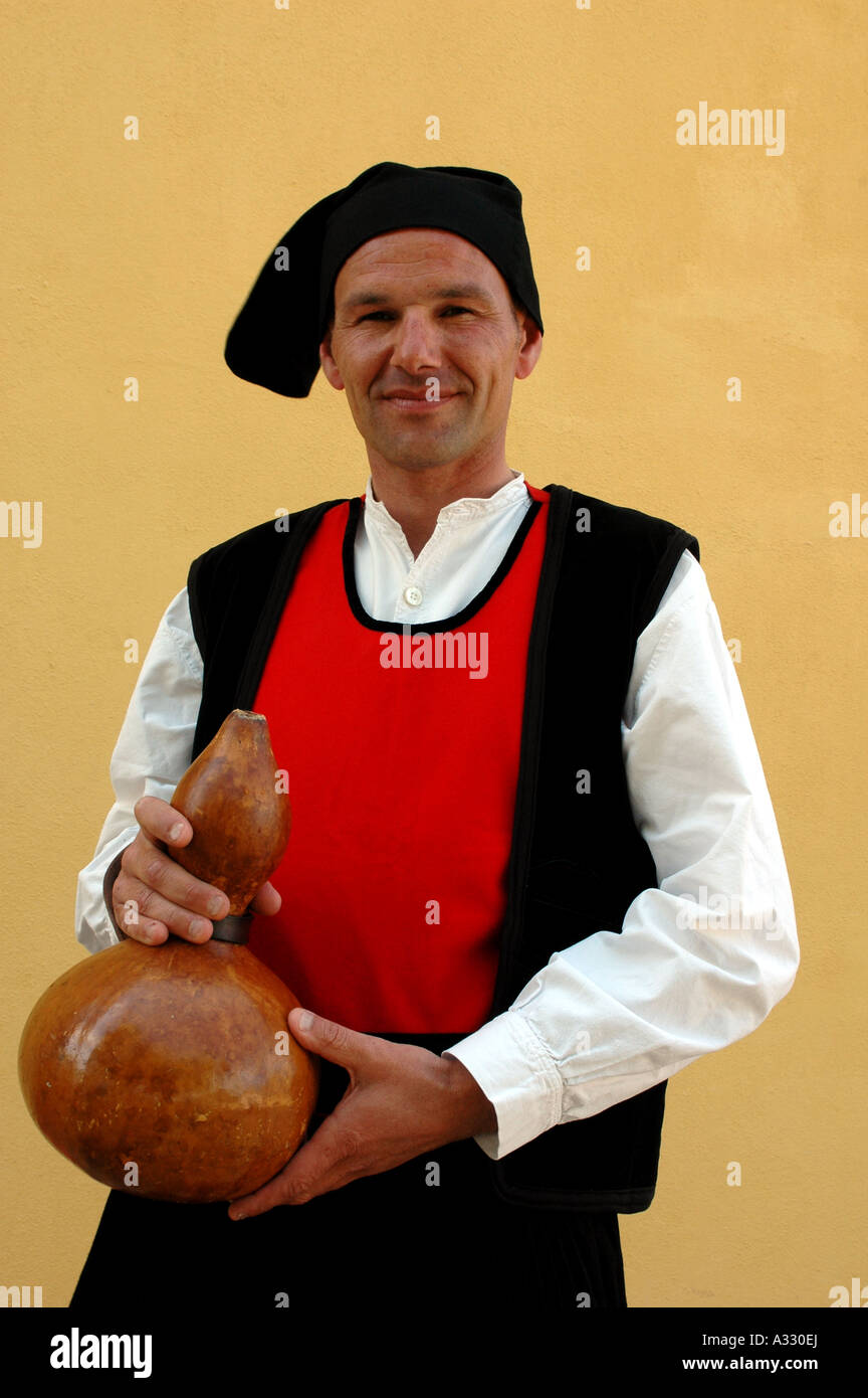 Man wearing a traditional Sardinian costume and holding a pumpkin used ...