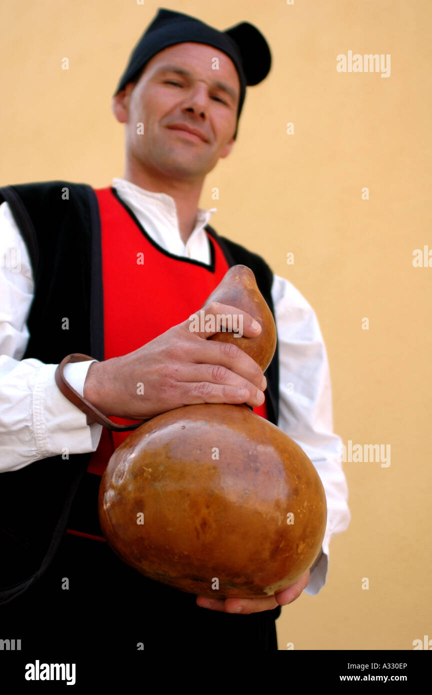 Man wearing a traditional Sardinian costume and holding a pumpkin used ...