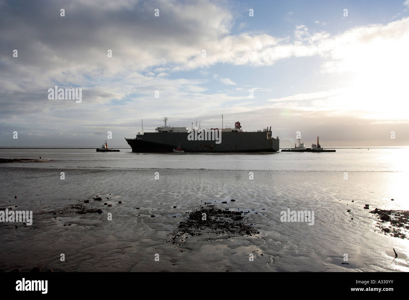 Tugboats piloting a cargo ship, Emden, Germany Stock Photo - Alamy
