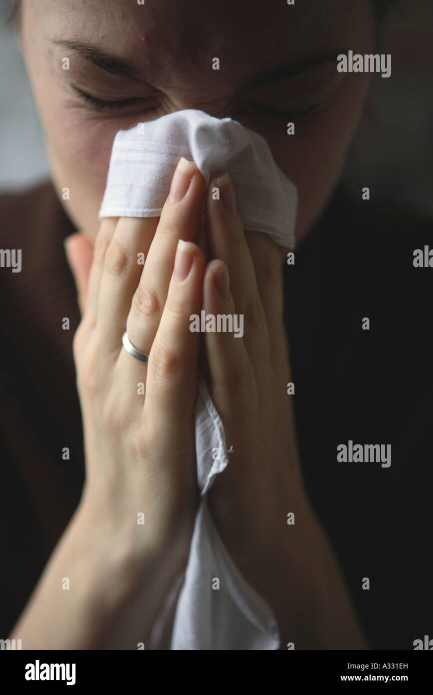 Female with cold/flu sneezing in her into a cloth handkerchief Stock ...