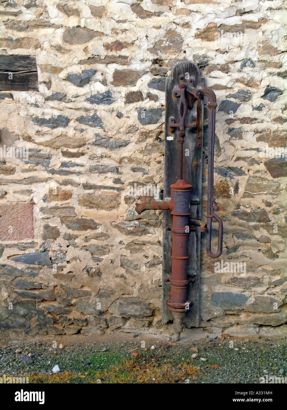 old rusty water pump at a house wall Stock Photo - Alamy
