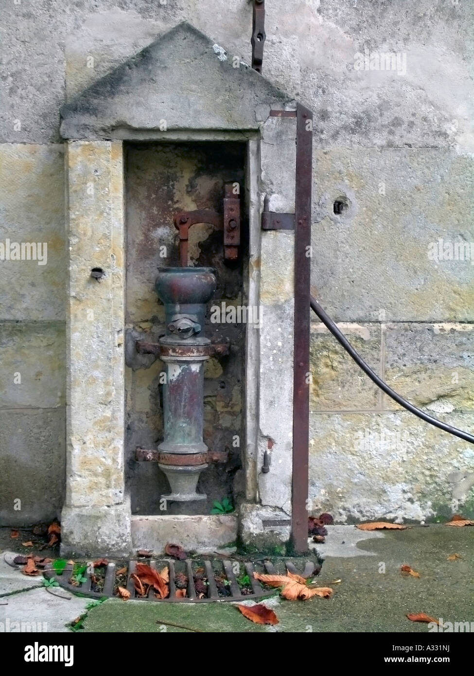 old rusty water pump at a house wall Stock Photo - Alamy