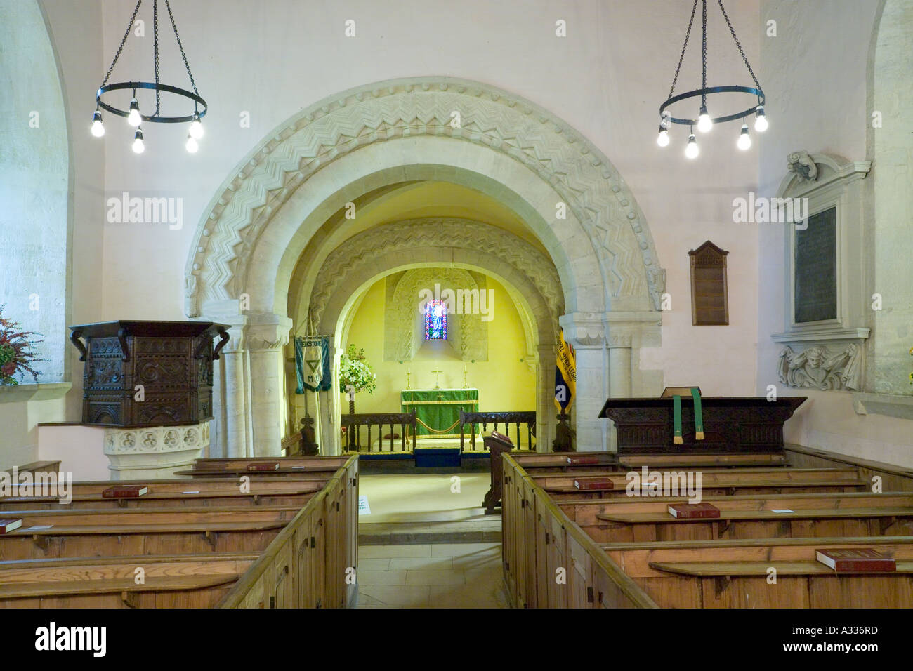 The interior of the Norman church of St John in the Cotswold village of ...