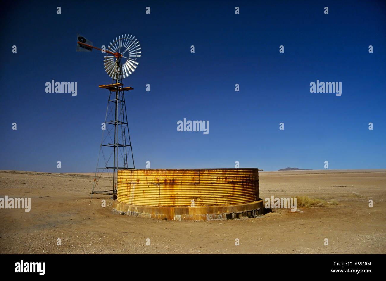 Windmill lift pump and water storage container Namib desert Namibia ...