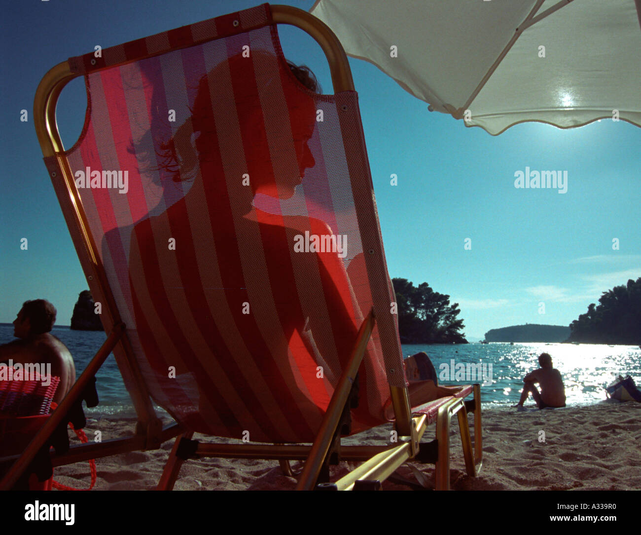 A sunbather relaxes on a beach in Samos Greece Stock Photo - Alamy