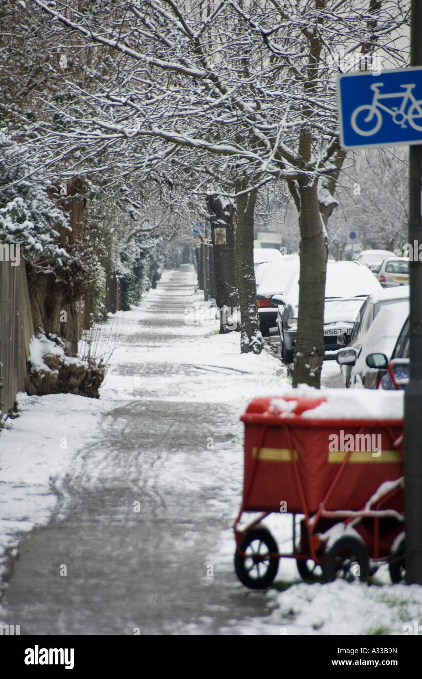 icy pavement, London suburban street with red postal trolley Stock ...
