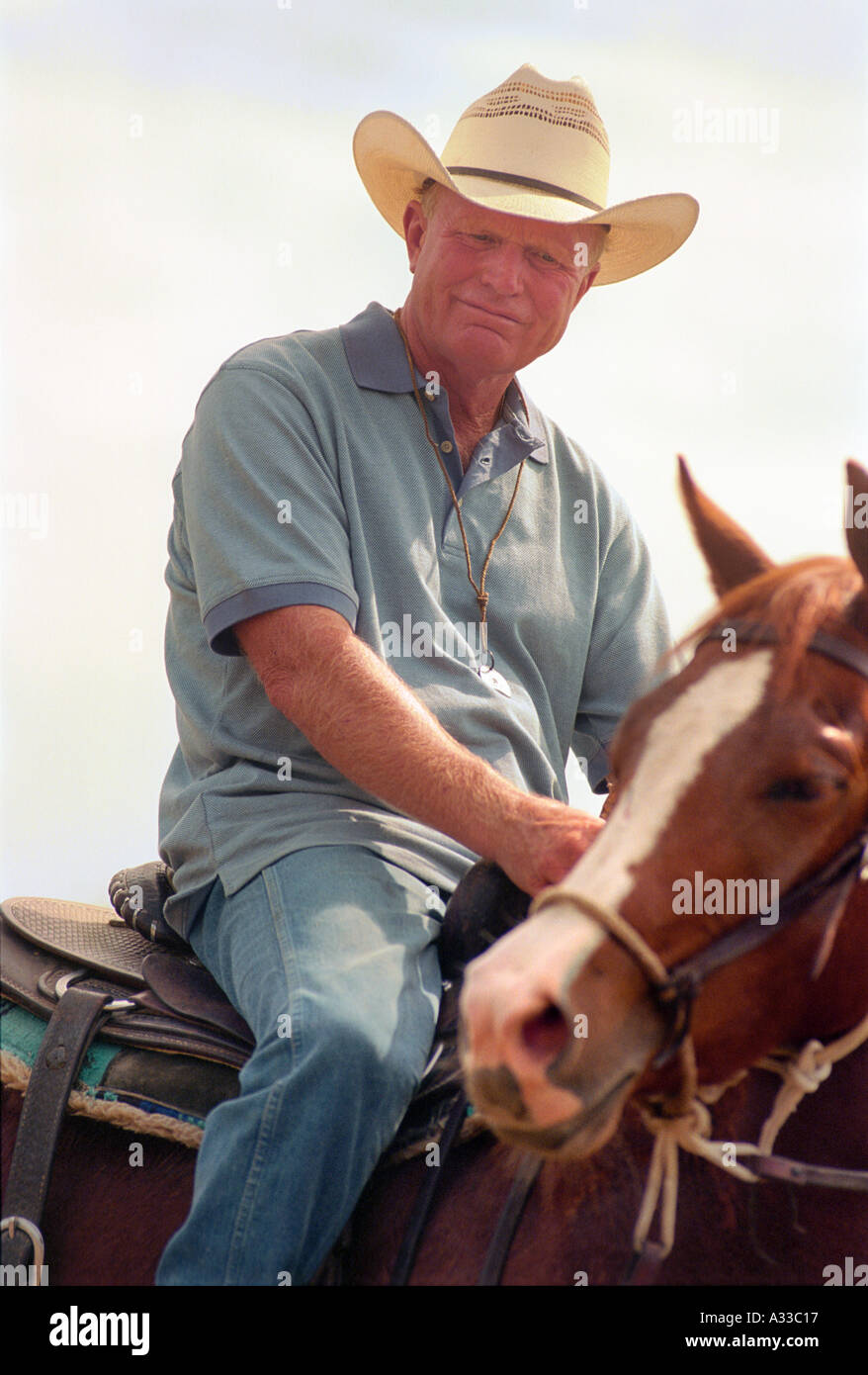 Senior man with cowboy hat riding a horse Stock Photo - Alamy