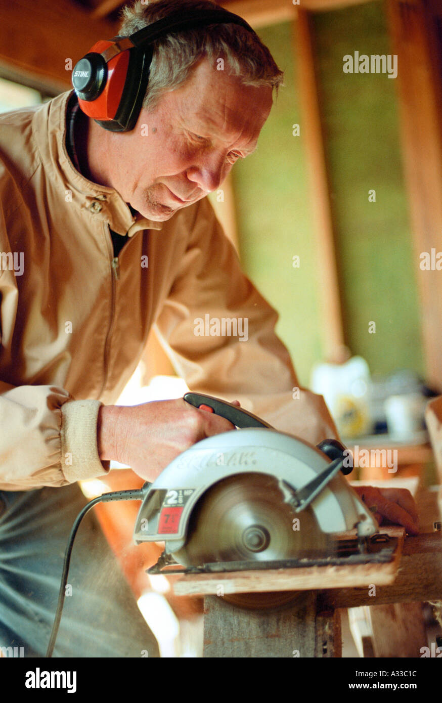 Senior man using circular saw in home construction Stock Photo - Alamy