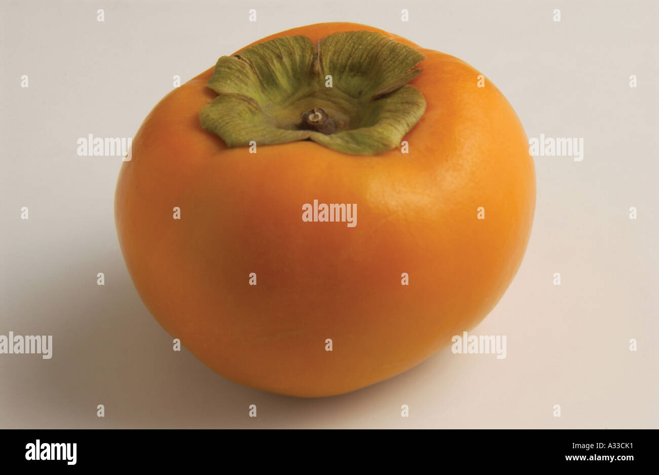 A persimmon on a surface Stock Photo - Alamy