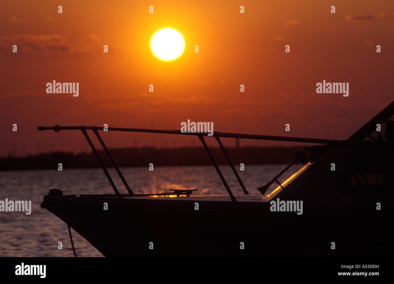 A sunset and a boat in the water on a bay Stock Photo - Alamy
