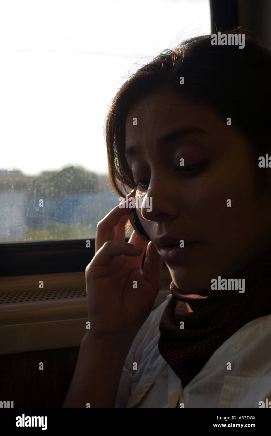 woman of costa rican ancestry on mobile phone on a train, looking ...