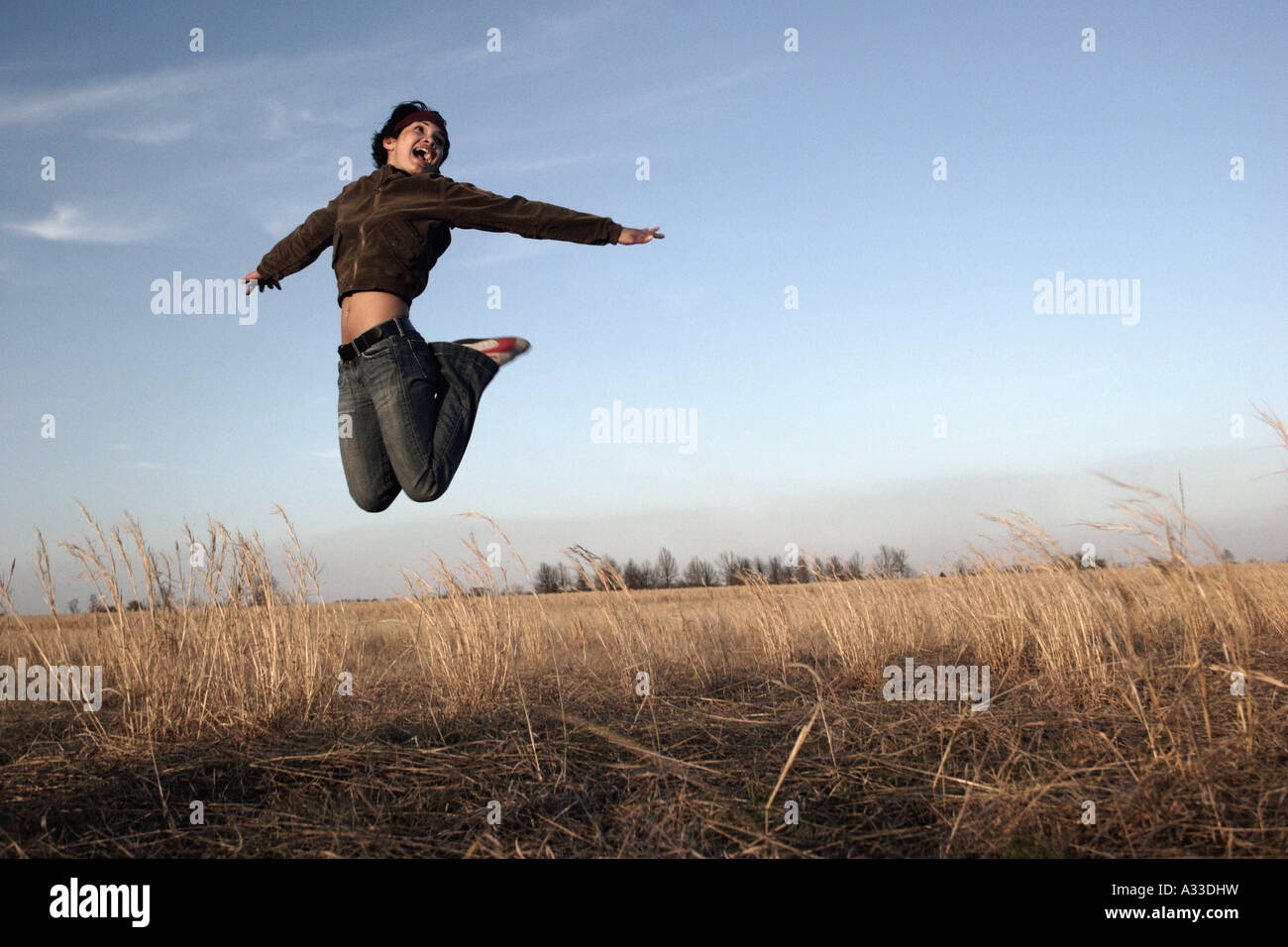 woman jumping with knees bent in wheatfield anywhrere, USA Stock Photo ...