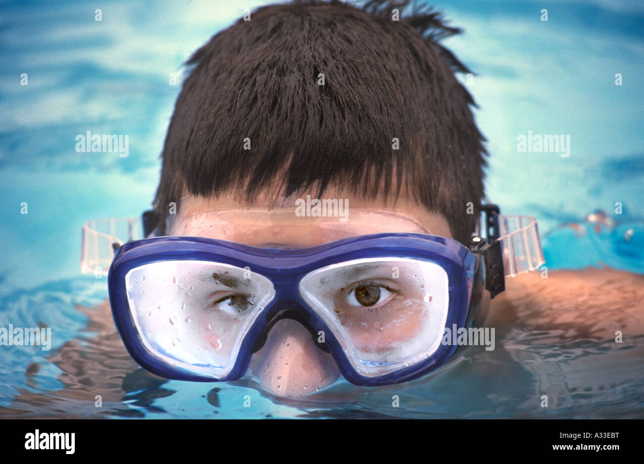 Young man wearing scuba mask and looking over the top of the water ...