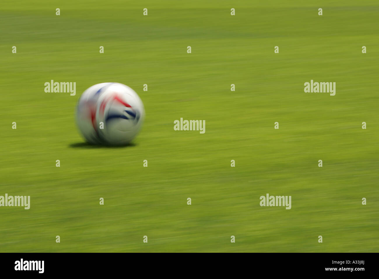 a blured football rolling along a nice green pitch Stock Photo - Alamy