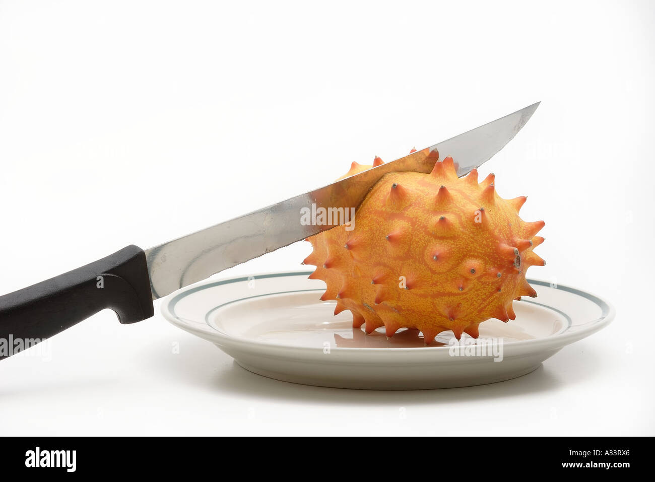 knife slicing through a kiwiano fruit Stock Photo - Alamy