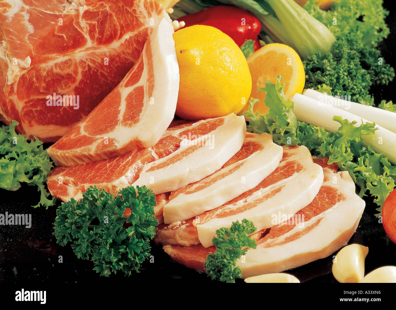 cut pork on the black surface with vegetables Stock Photo - Alamy