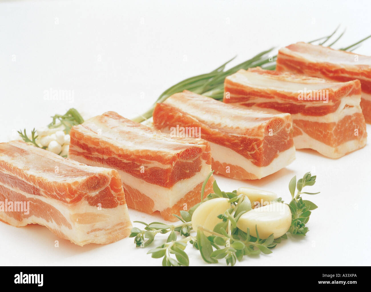 Five pieces of pork belly laid with garlics and spring onions Stock ...