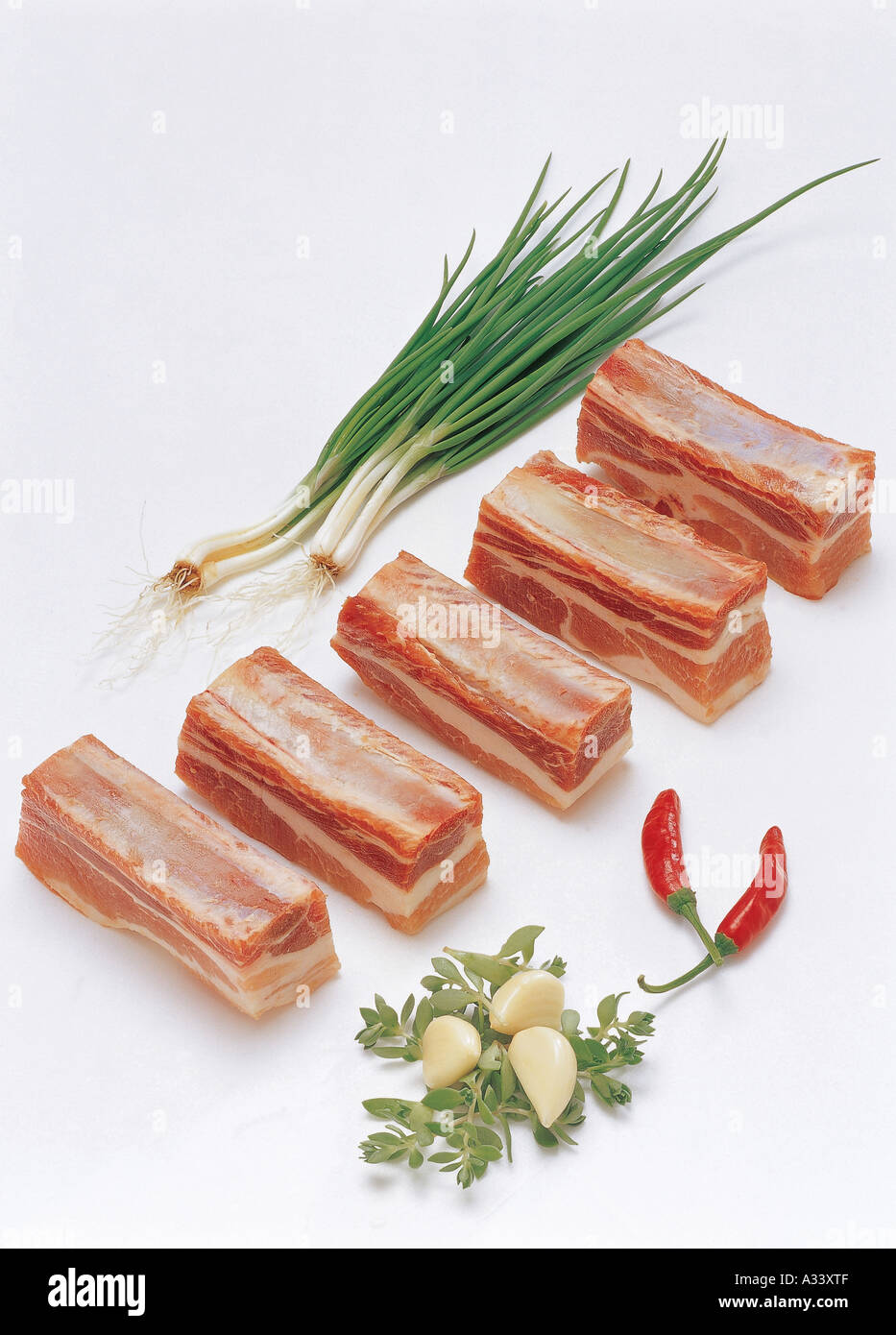 Five pieces of pork belly laid with red peppers, garlics and spring ...