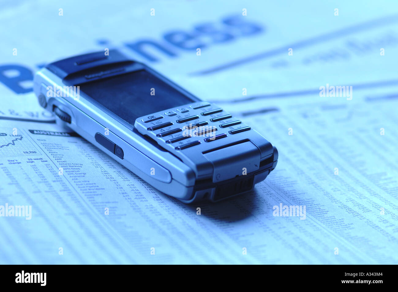 business newspaper with mobile phone, pda Stock Photo - Alamy