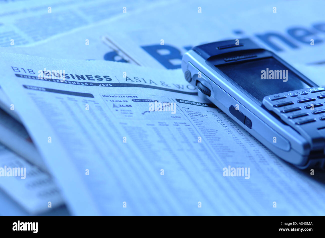 business newspaper with mobile phone, pda Stock Photo - Alamy