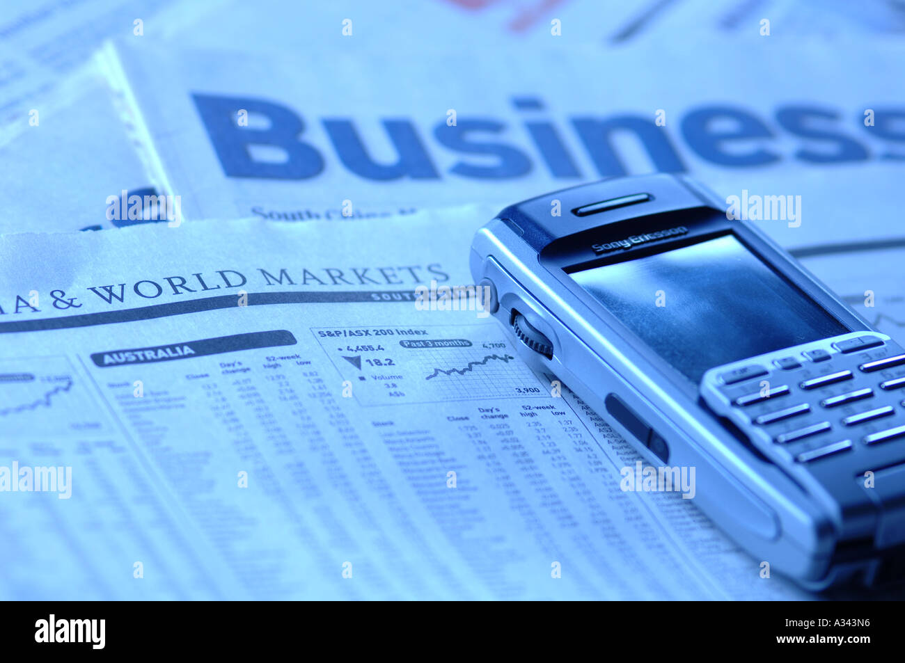 business newspaper with mobile phone, pda Stock Photo - Alamy