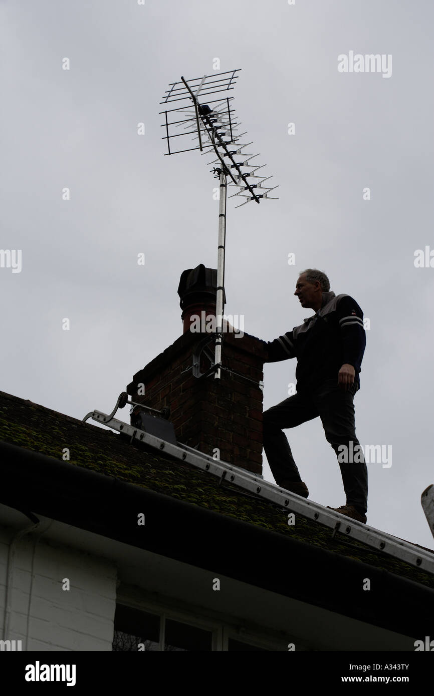 Man checking new digital television aerial attached to chimney Stock ...
