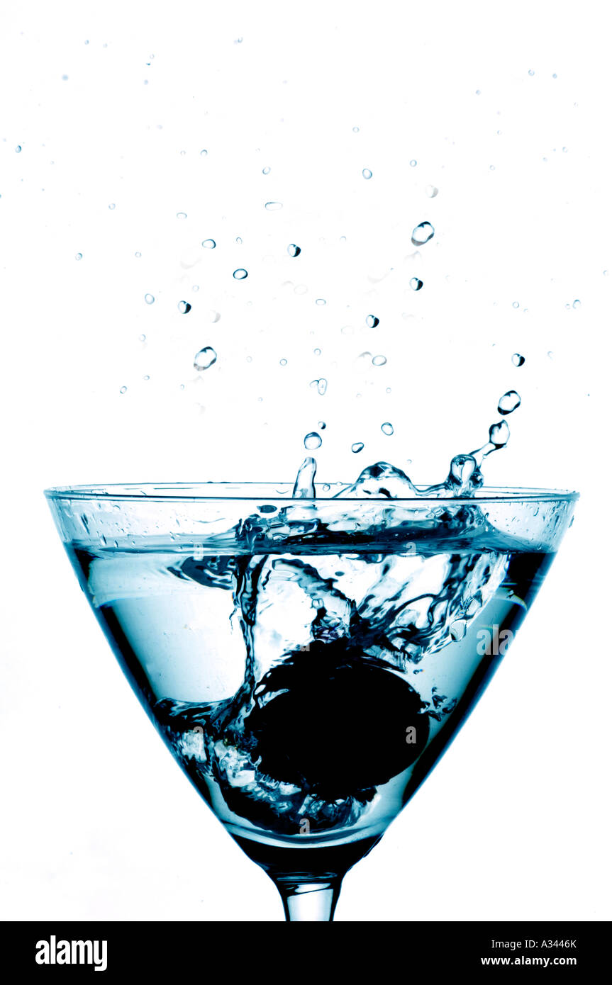 Close up of a splash of water in a martini glass on a white background ...