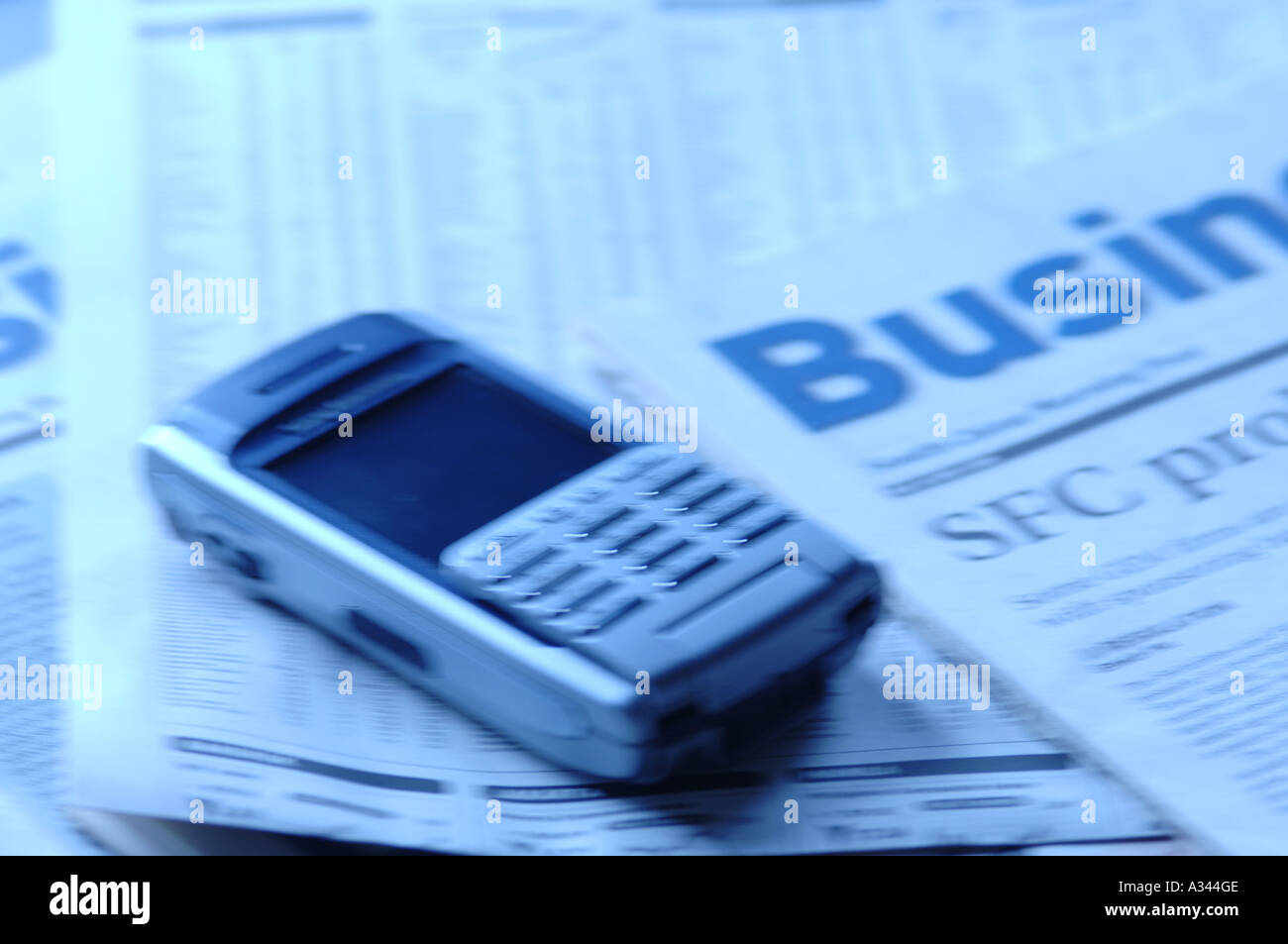 business newspaper with mobile phone, pda Stock Photo - Alamy