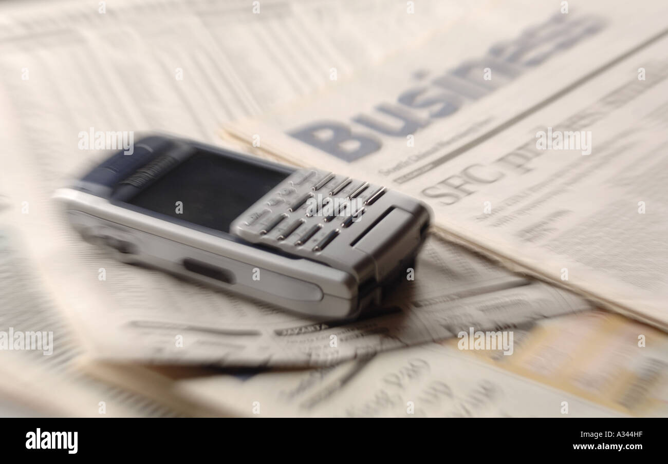 business newspaper with mobile phone, pda, blurred, zooming Stock Photo ...