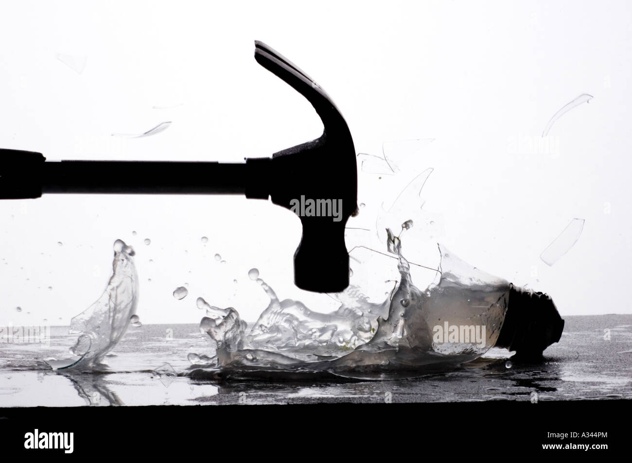 Hammer breaking a conventional light bulb on a white background Stock ...