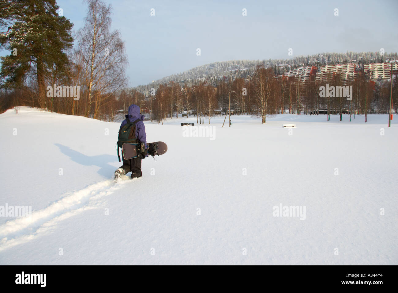 capital city, Norway, Oslo, Oslo City. A female snow boarder hikes ...