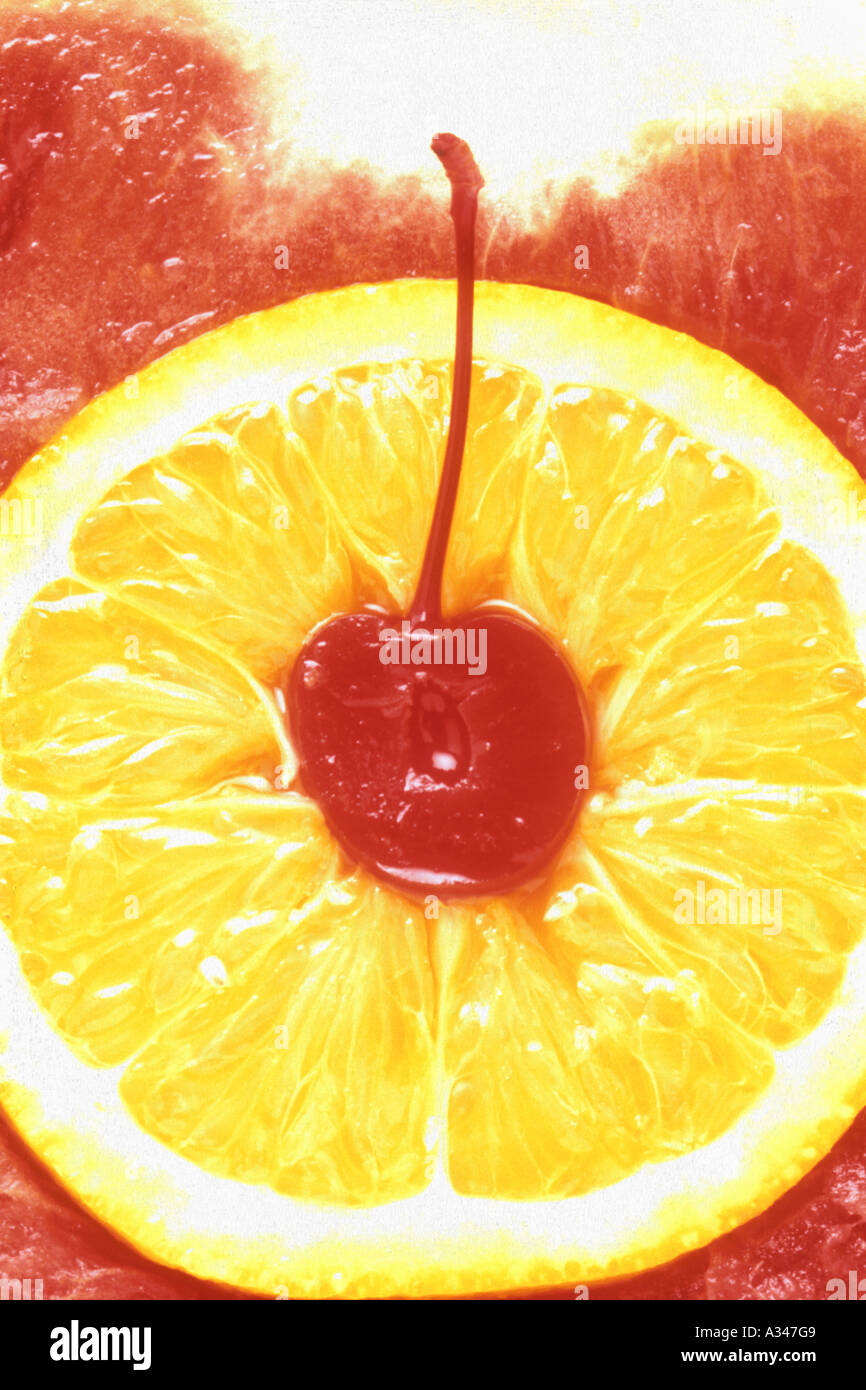 A cherry is halved and place in the middle of an orange producing a ...