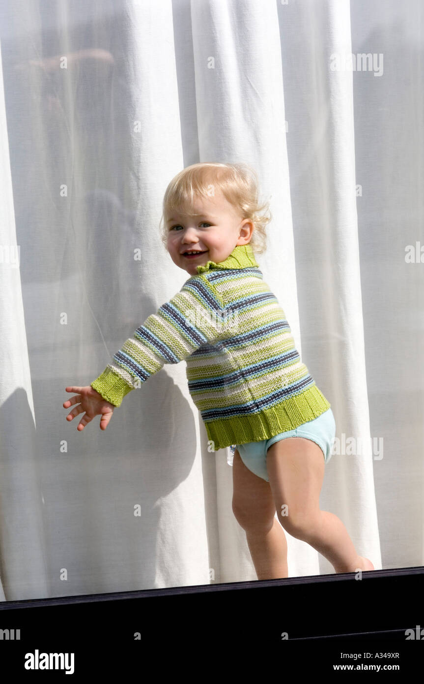 Little boy standing behind window Stock Photo - Alamy