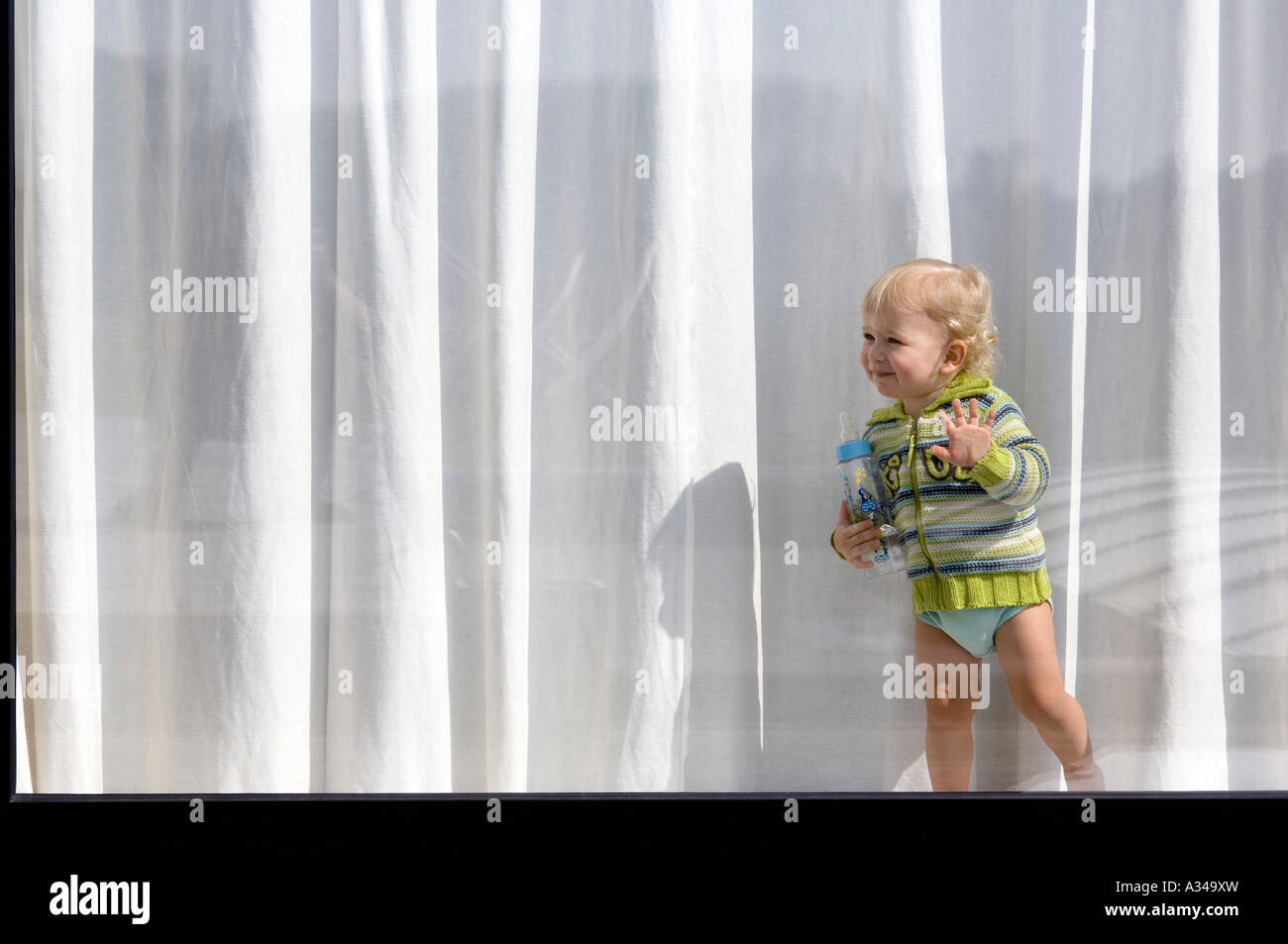 Little boy standing behind window Stock Photo - Alamy
