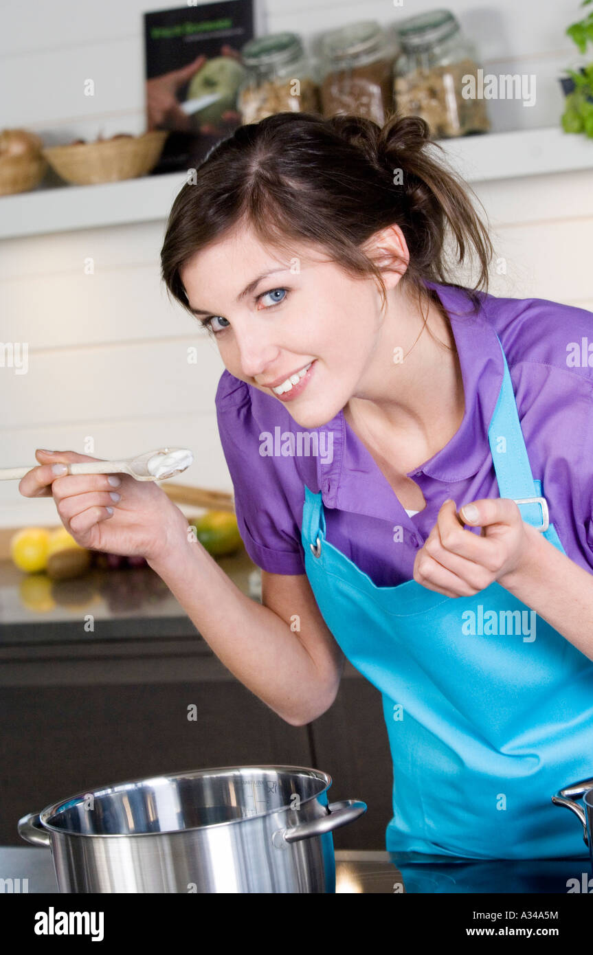 Young smiling woman tasting food Stock Photo - Alamy