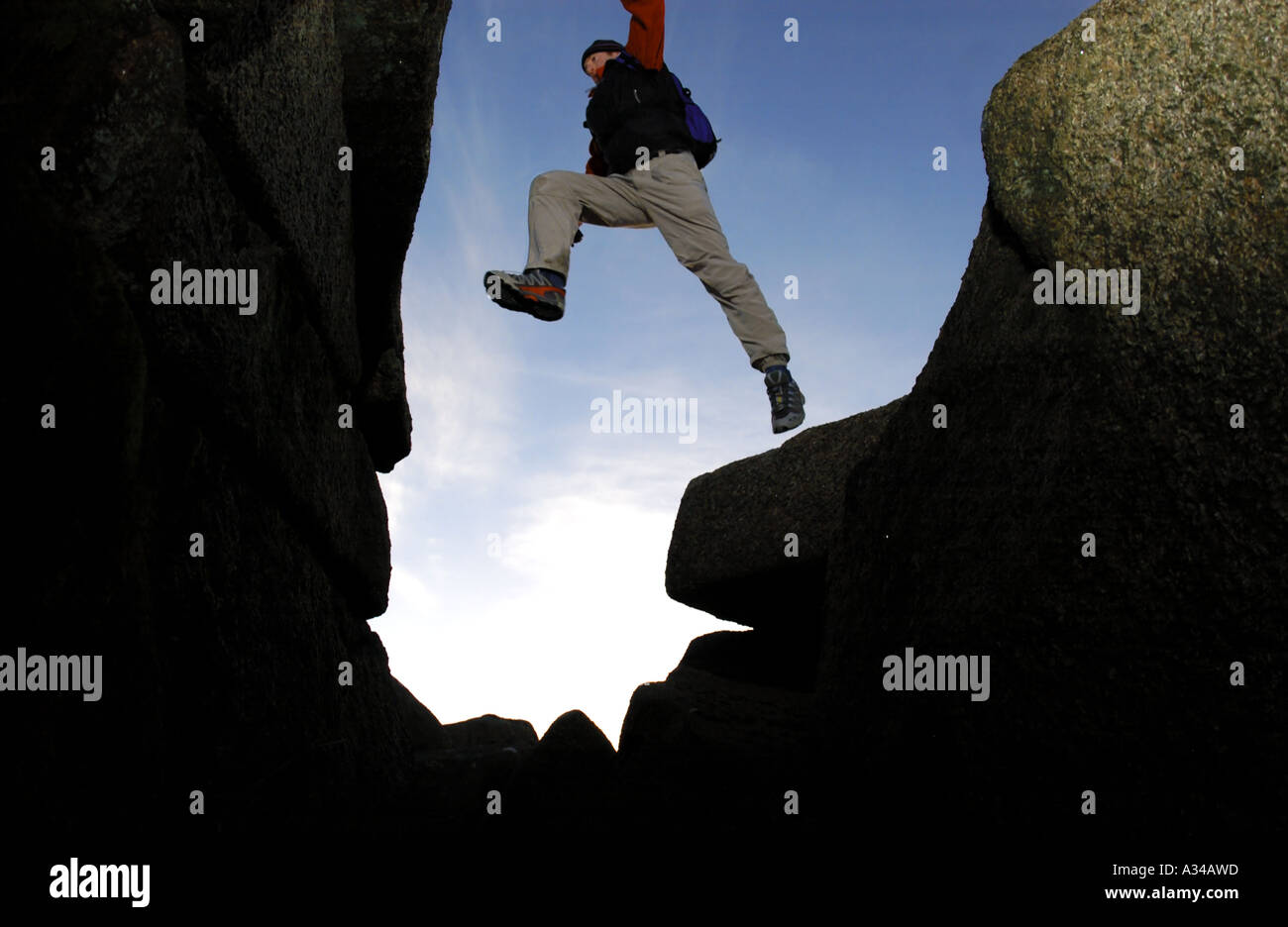 man jumping over between rocks on trowlesworthy tor dartmoor Stock ...